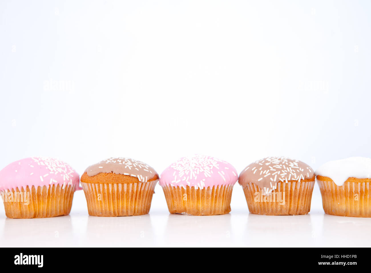 Muffins lined up against a white background Stock Photo - Alamy