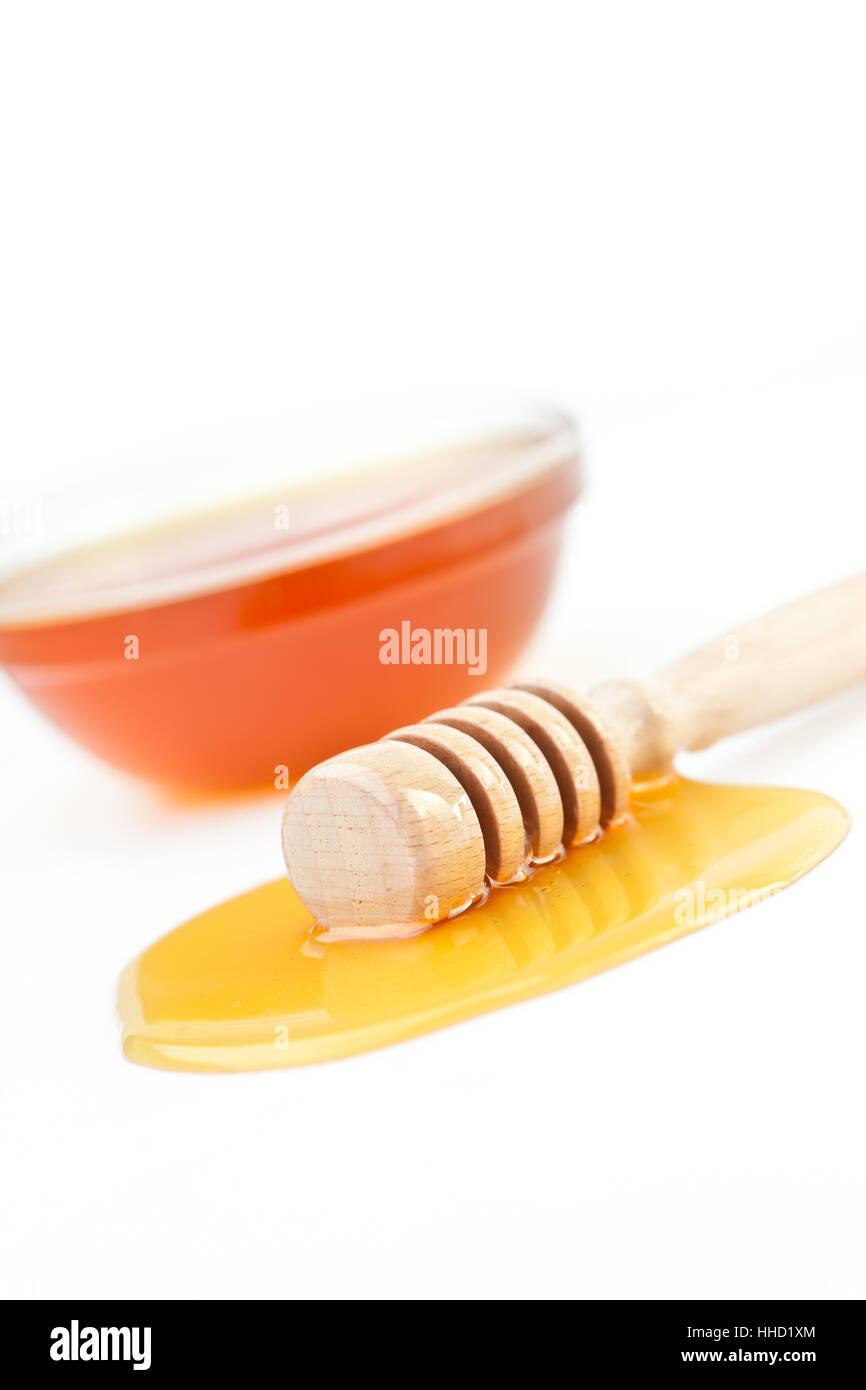 Honey dipper on the floor spilling honey in front of a honey bowl ...