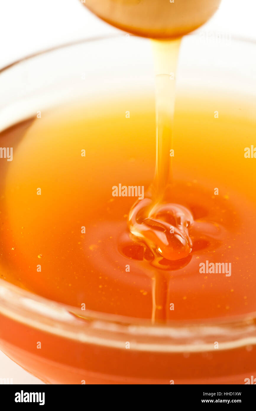 Close up of a thin honey trickle against a white background Stock Photo ...