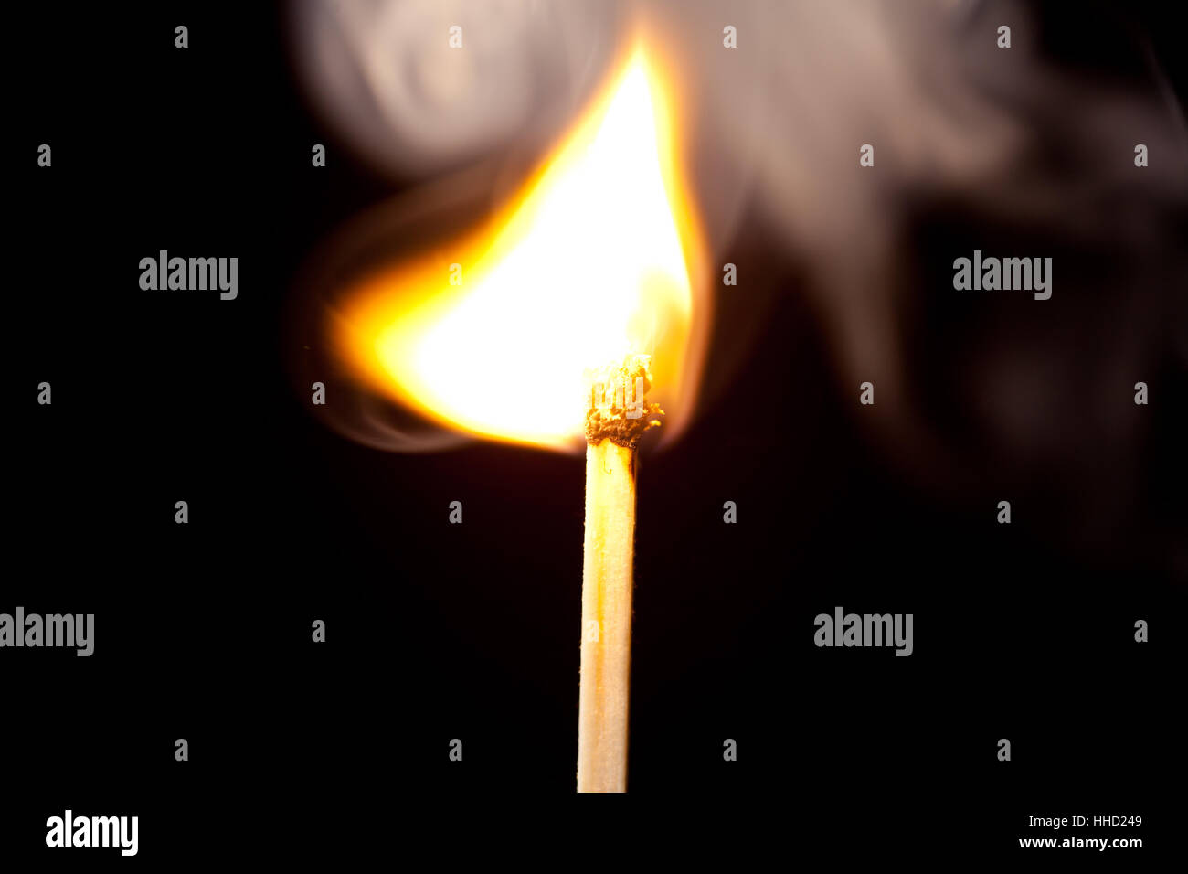Match set on fire against a black background Stock Photo - Alamy