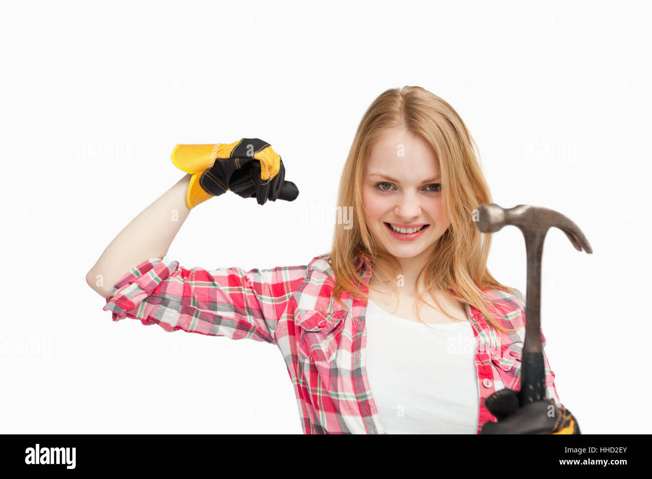 Woman smiling while holding a hammer against white background Stock ...