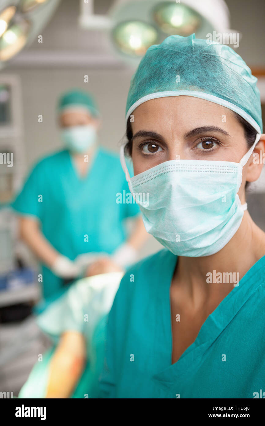 Serious surgeon standing in front of a colleague in a surgical room ...