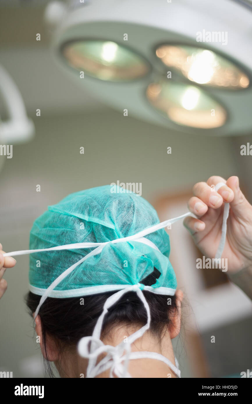 Woman surgeon putting a surgical hat on in a surgery room Stock Photo ...