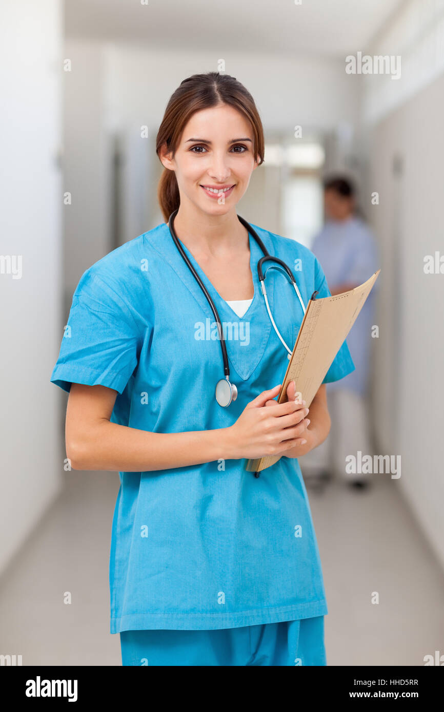 Smiling nurse holding a file while standing in a hallway Stock Photo ...