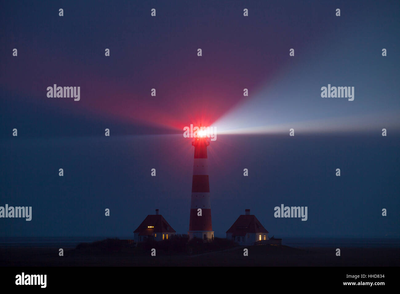Lighthouse Westerhever emitting cone of light into the night ...