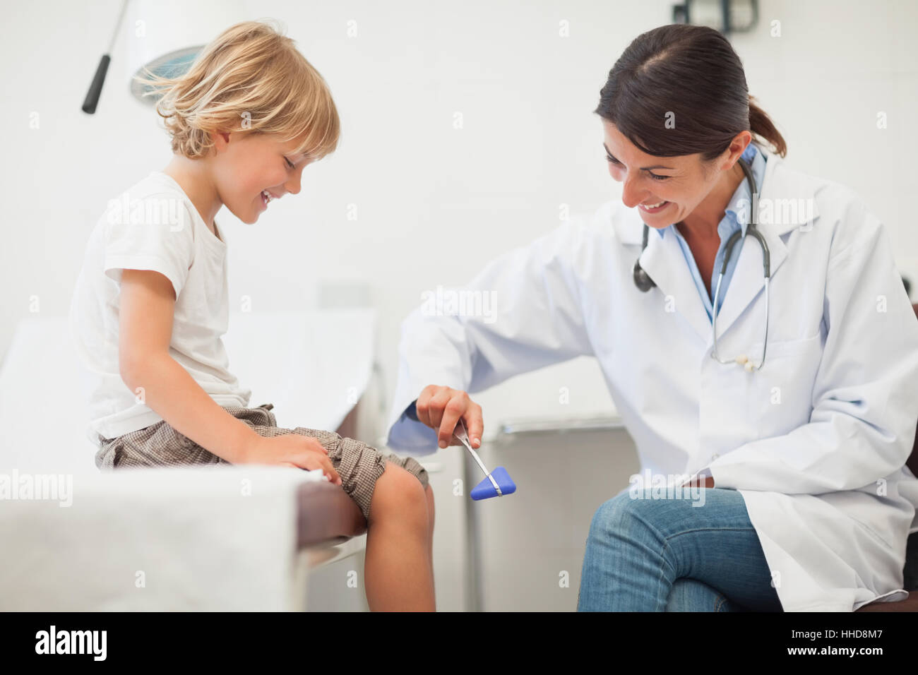 Doctor testing reaction of a child leg in examination room Stock Photo ...