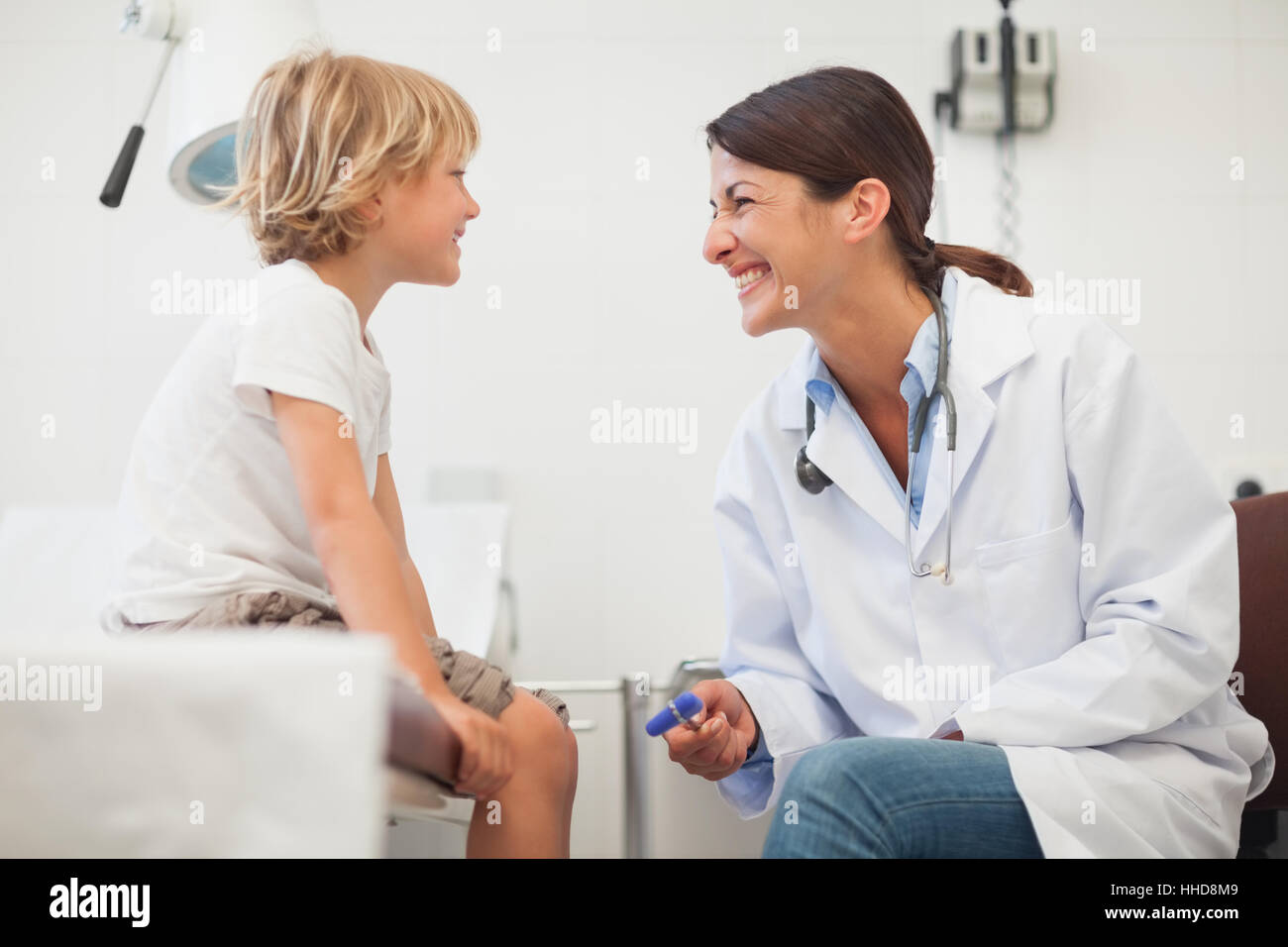 Doctor smiling to a child in examination room Stock Photo - Alamy