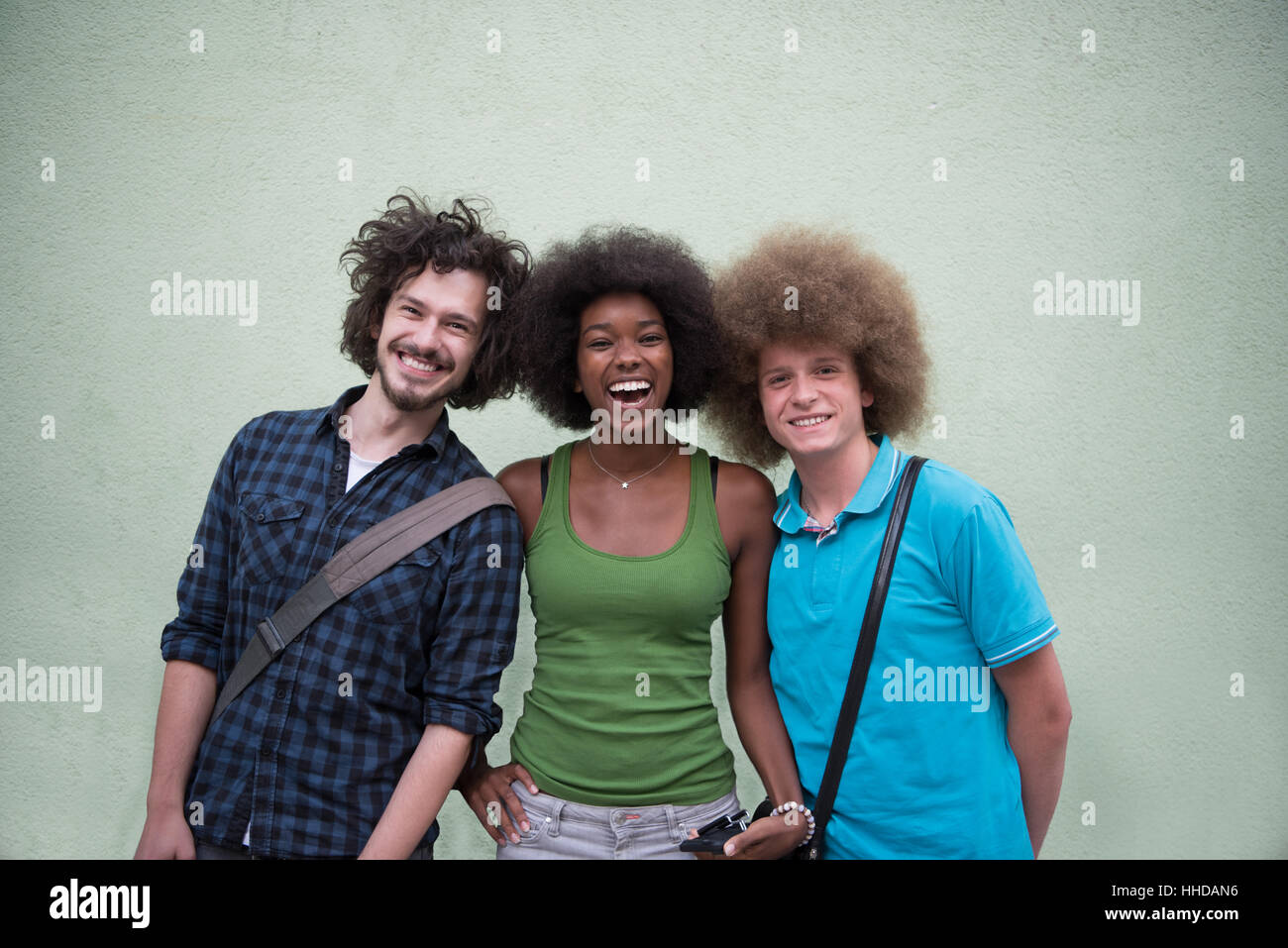 Portrait of multiethnic group of happy three friends in casual wear ...