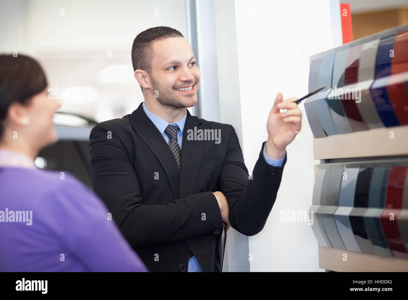 Smiling salesman pointing at a color palette with a woman Stock Photo ...