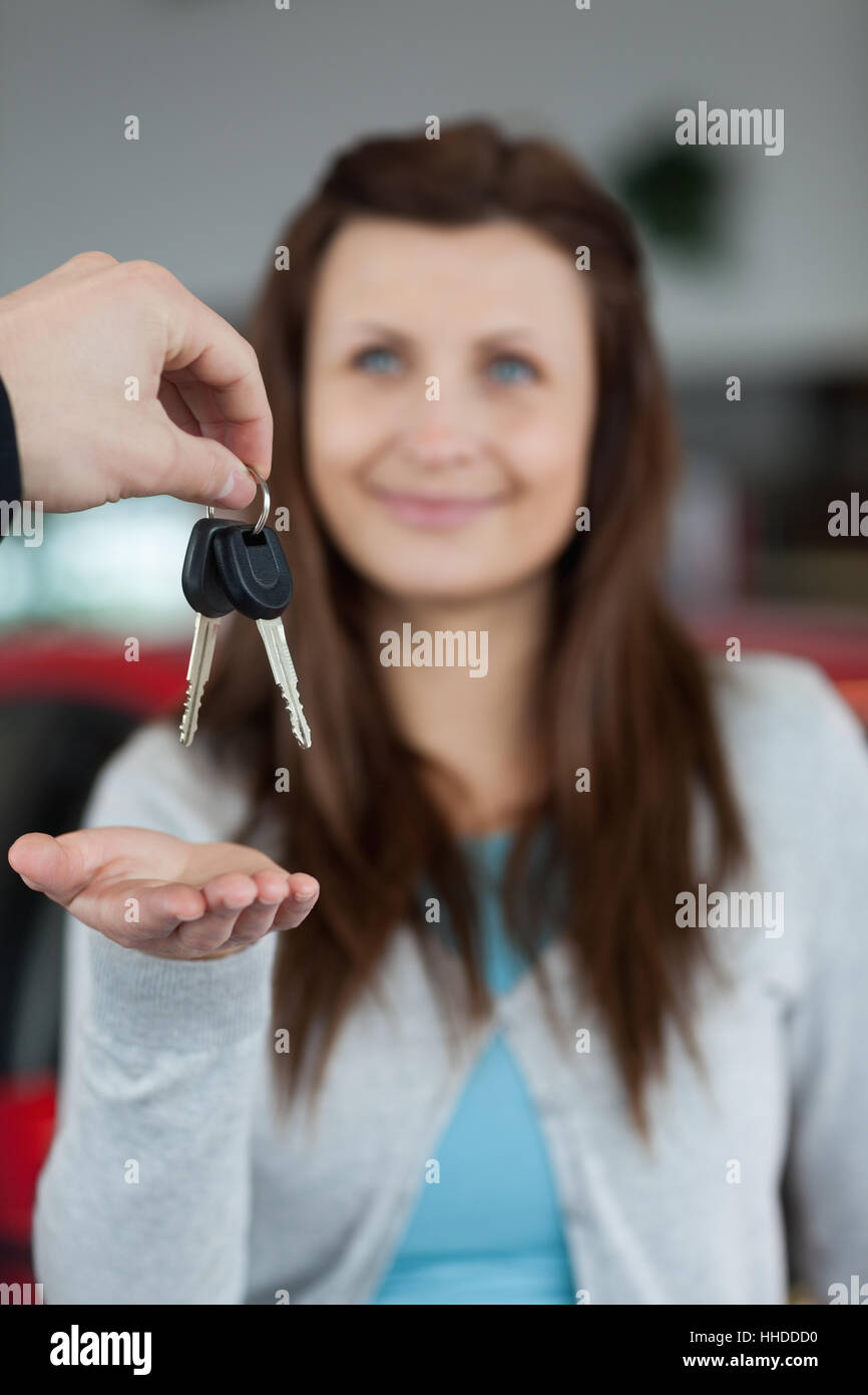 Happy brunette receiving car keys in a garage Stock Photo - Alamy