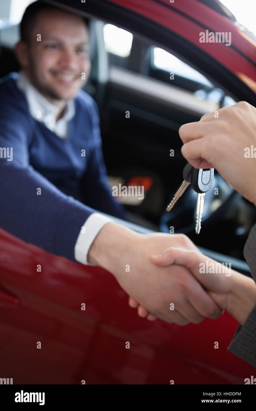 Customer receiving car keys while shaking hand in a garage Stock Photo ...