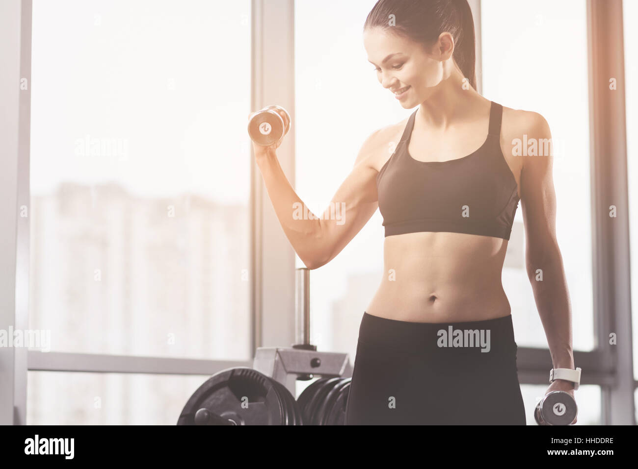 Active woman using dumbbells while training Stock Photo - Alamy