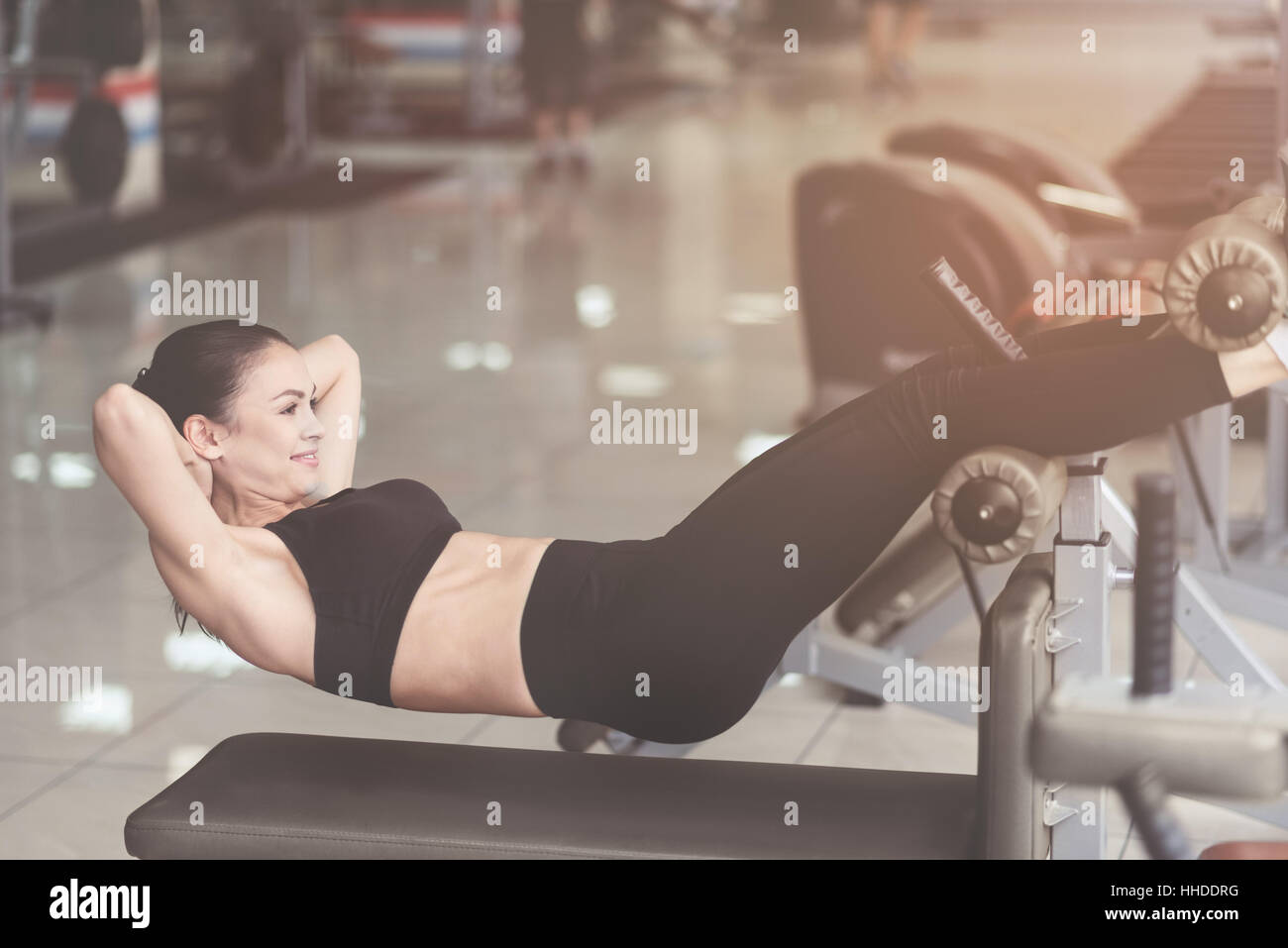 Delighted woman doing sit ups while training Stock Photo - Alamy
