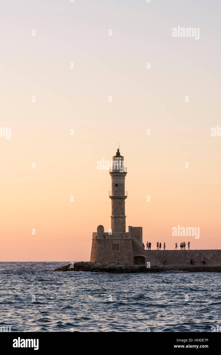 Sunset over the Chania lighthouse at the entrance to the Venetian ...