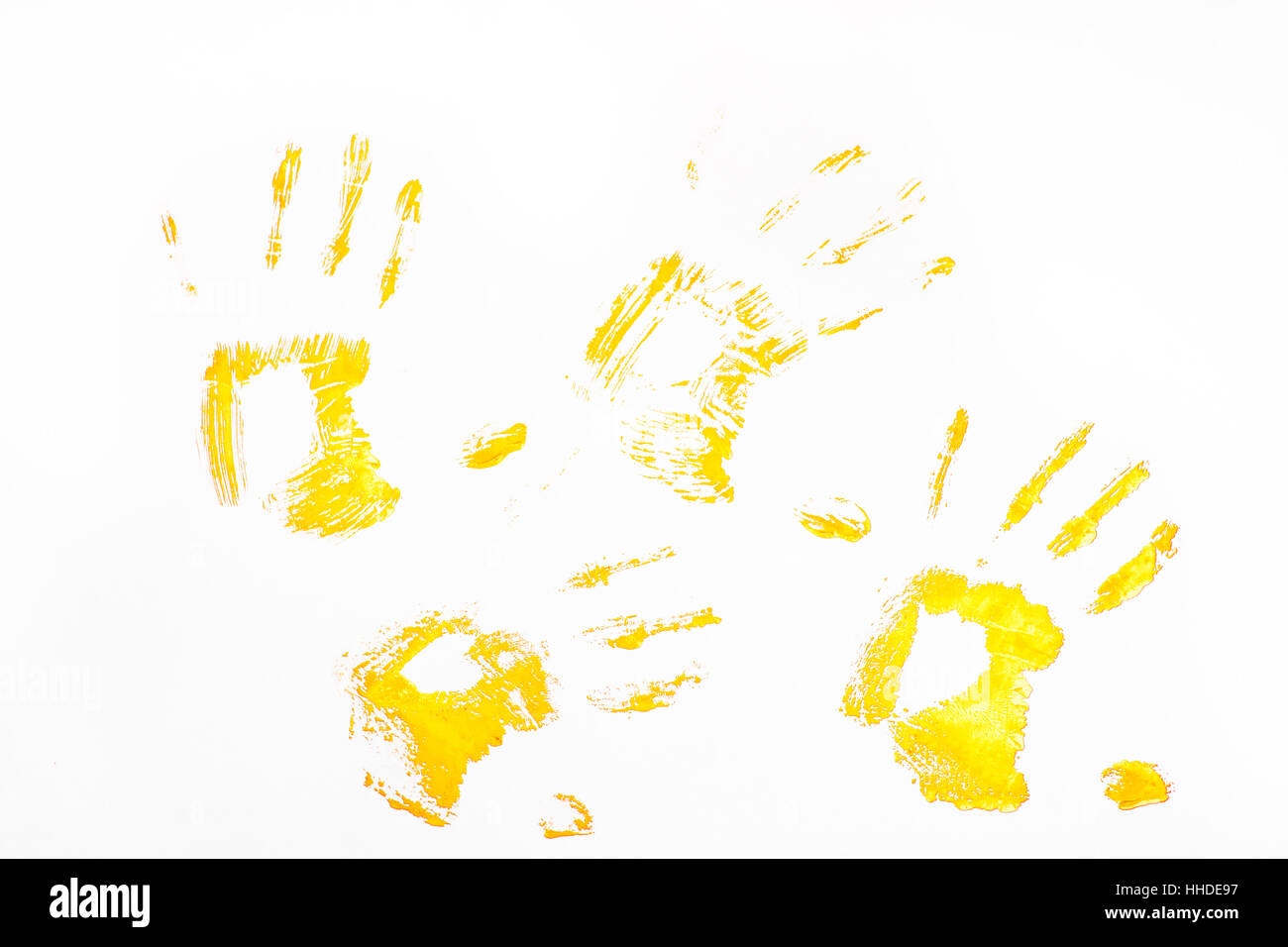 Four yellow handprints against a white background Stock Photo - Alamy