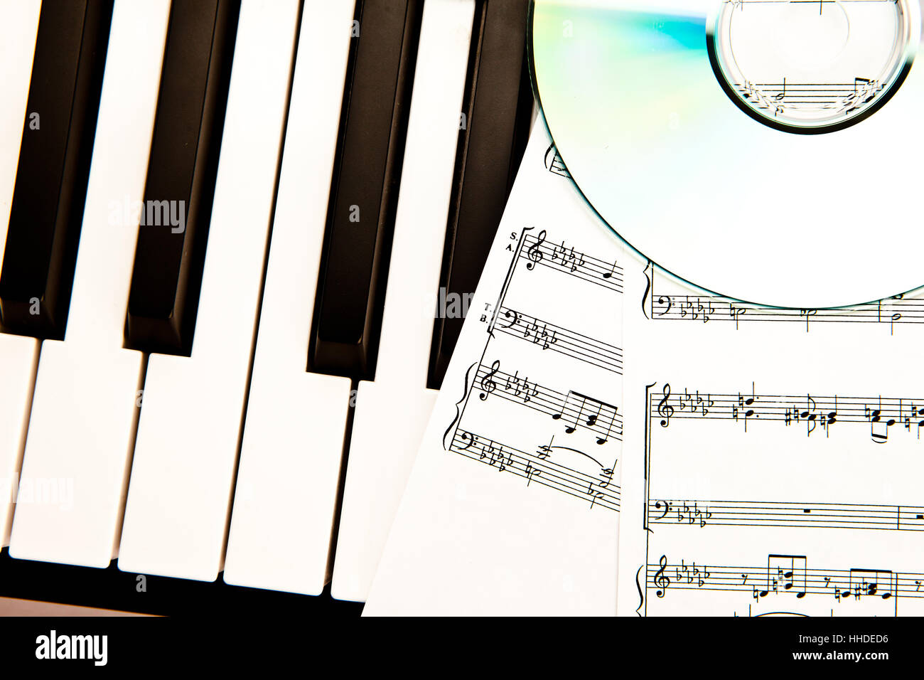 Compact disc and music scores placed on piano keyboard Stock Photo - Alamy