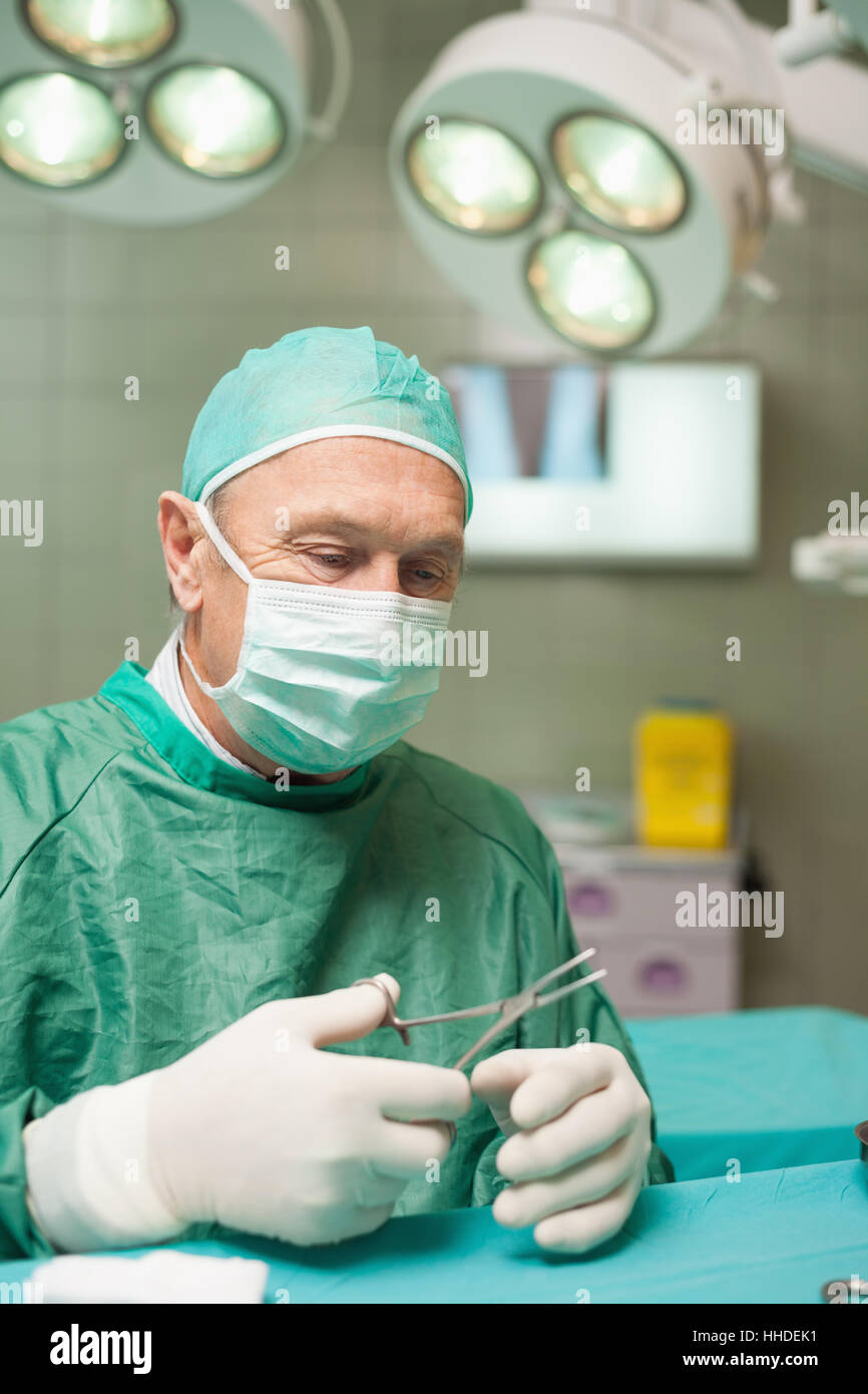 Surgeon holding scissors in a surgical room Stock Photo - Alamy