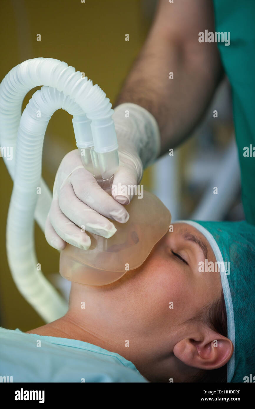 Surgeon placing a mask in the face of a patient in a surgical room ...