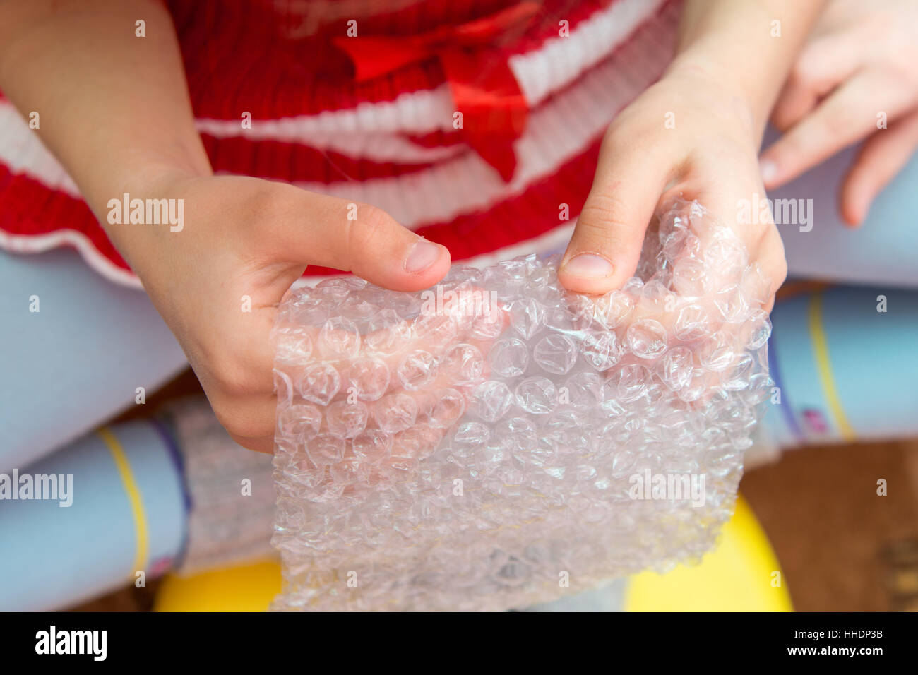 Top view of the child's hands pressing the bubbles on the packaging ...