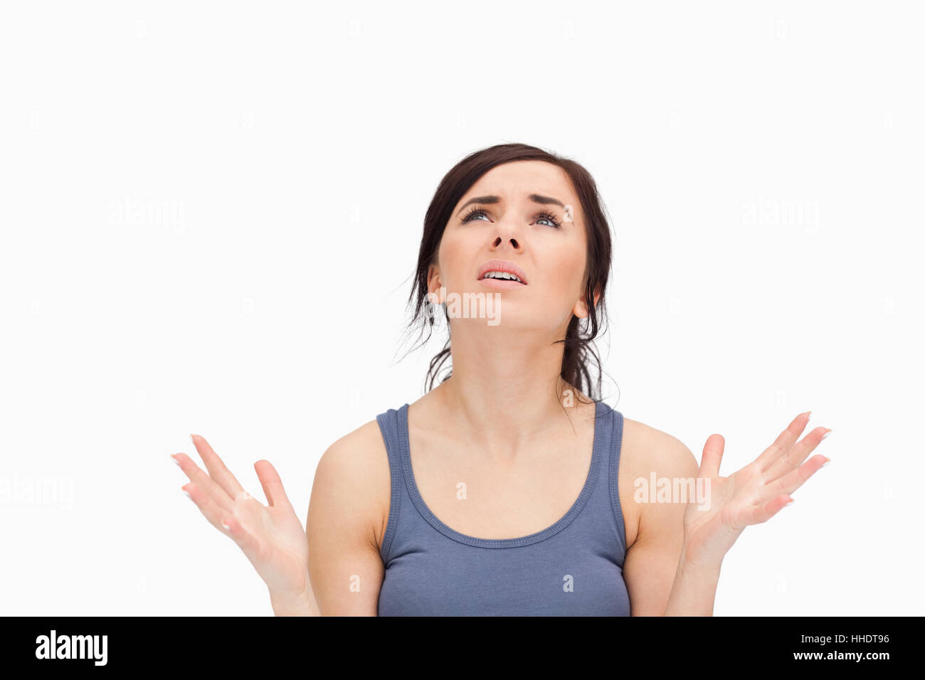 Young woman begging while looking up against white background Stock ...