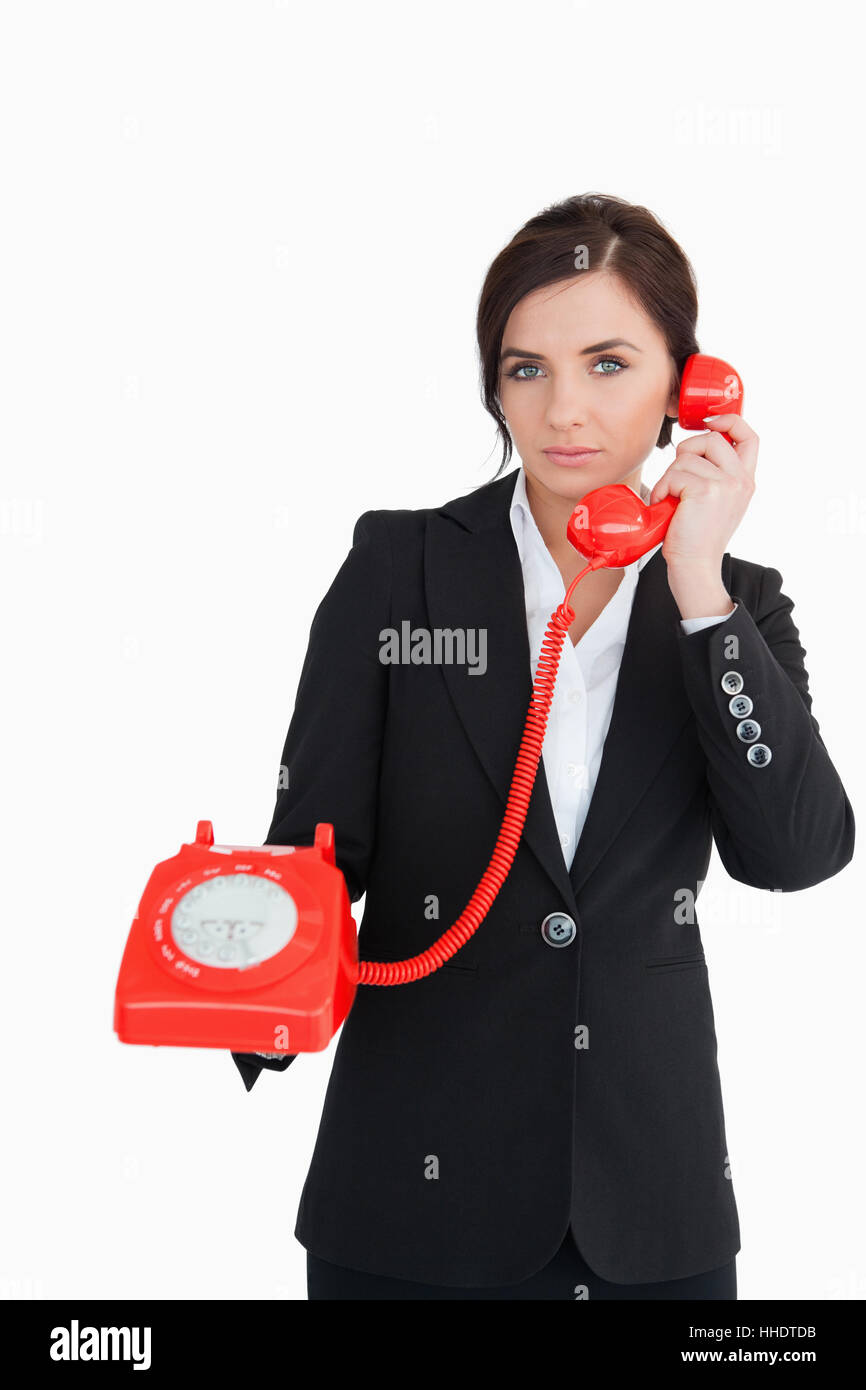Businesswoman using a red dial telephone against white background Stock ...