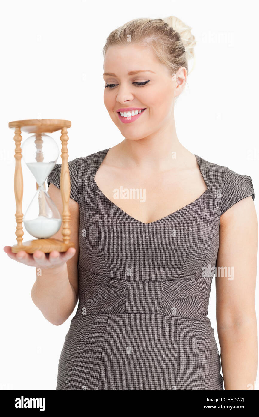 Woman looking a hourglass on her hand against white background Stock ...