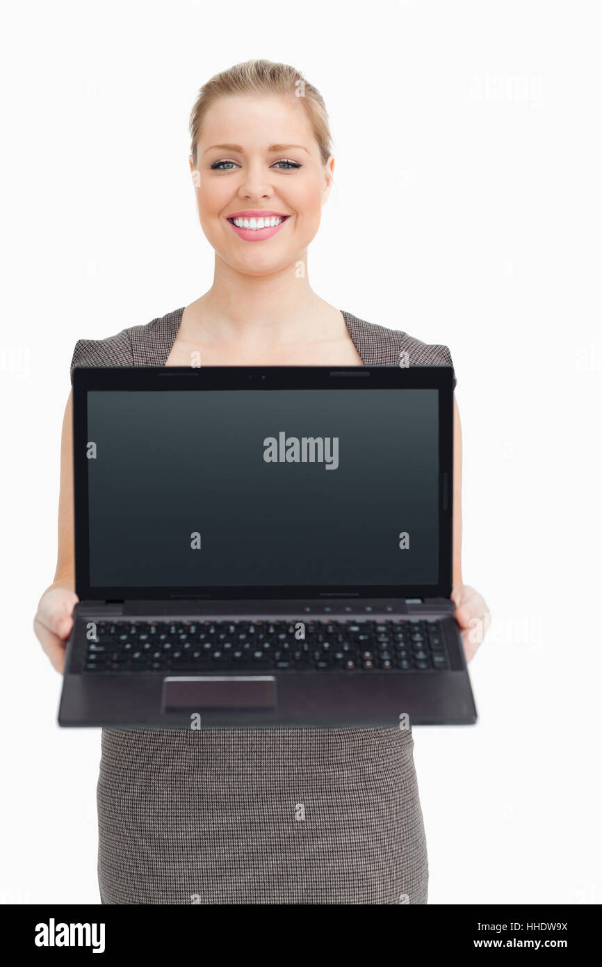 Woman standing while showing a laptop against white background Stock ...