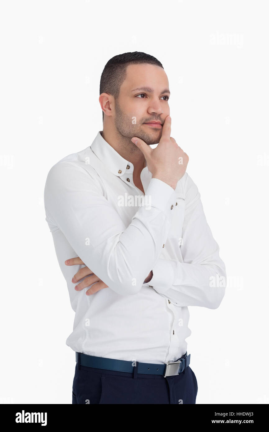 Thoughtful man standing and crossing his arms against a white ...