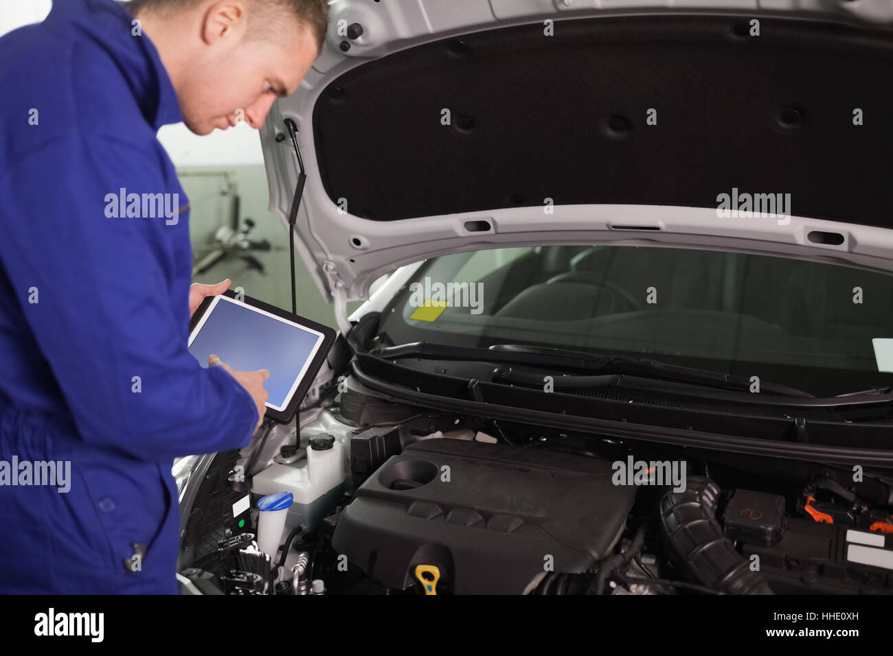 Mechanic using a tablet computer in a garage Stock Photo - Alamy