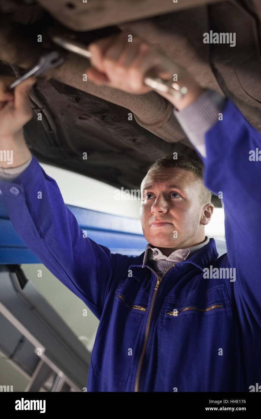 Concentrated mechanic repairing with tools in a garage Stock Photo - Alamy