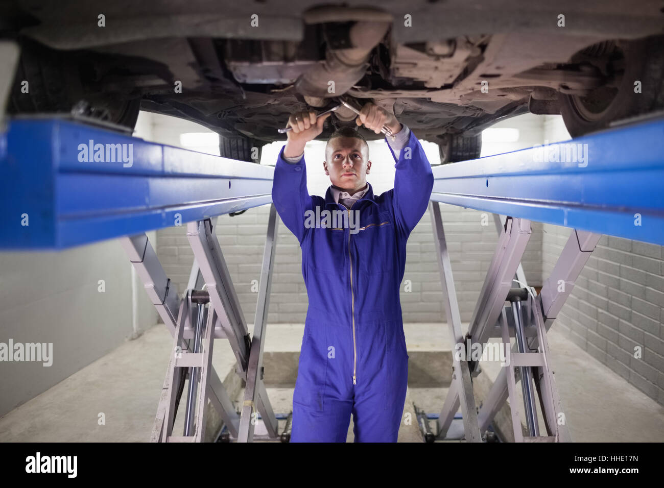 Mechanic repairing a car with tools in a garage Stock Photo - Alamy
