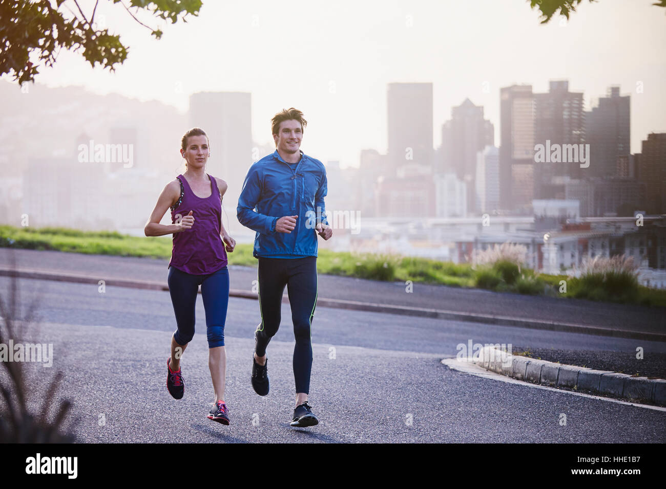 Runner couple running on urban city street Stock Photo - Alamy