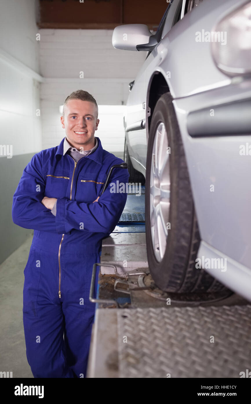 Front view of a mechanic smiling next to a car in a garage Stock Photo ...