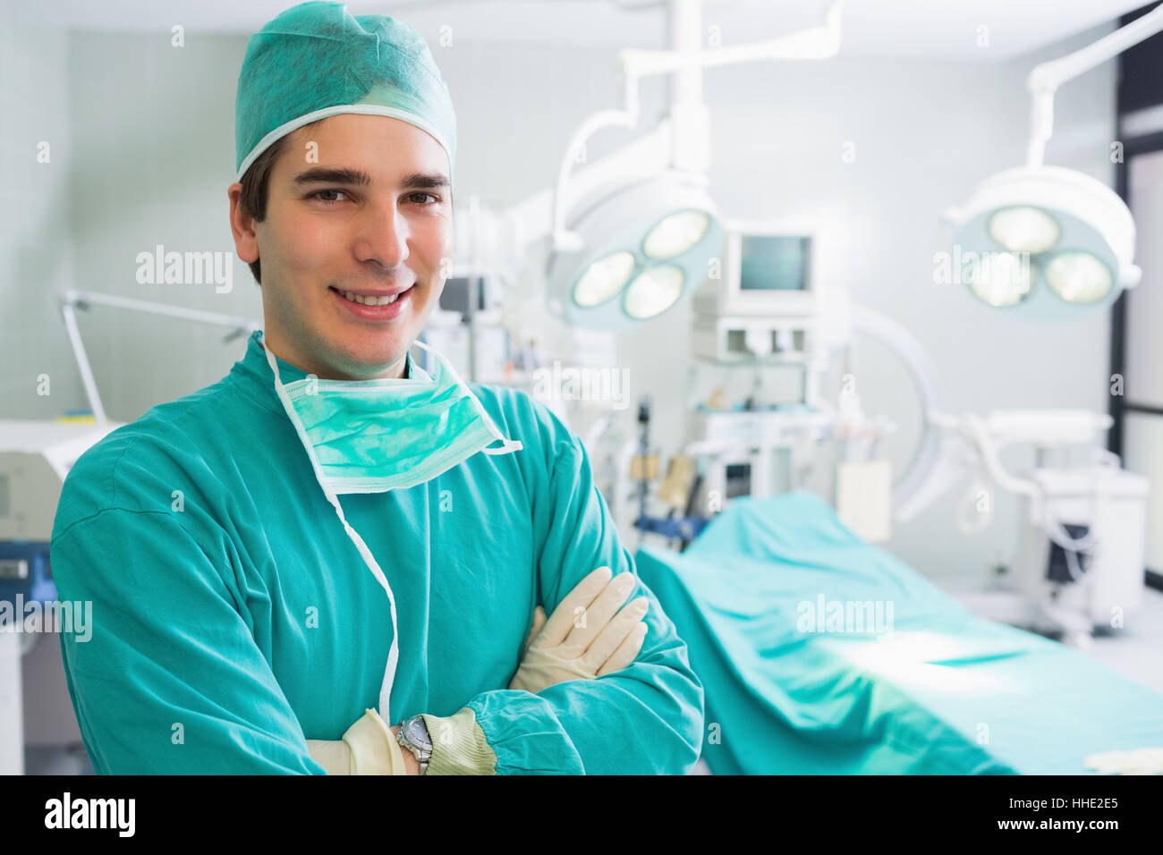 Surgeon smiling with arms crossed in an operating theatre Stock Photo ...