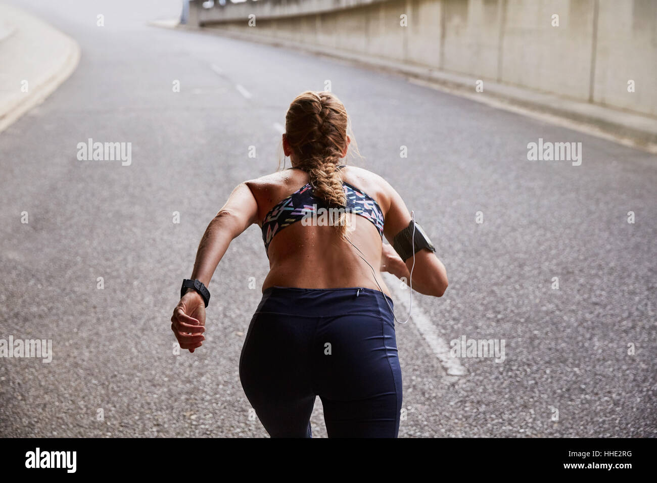 Fit female runner with mp3 player armband running on urban street Stock ...