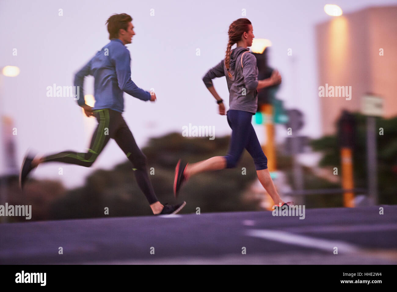 Runner couple running on urban city street Stock Photo - Alamy