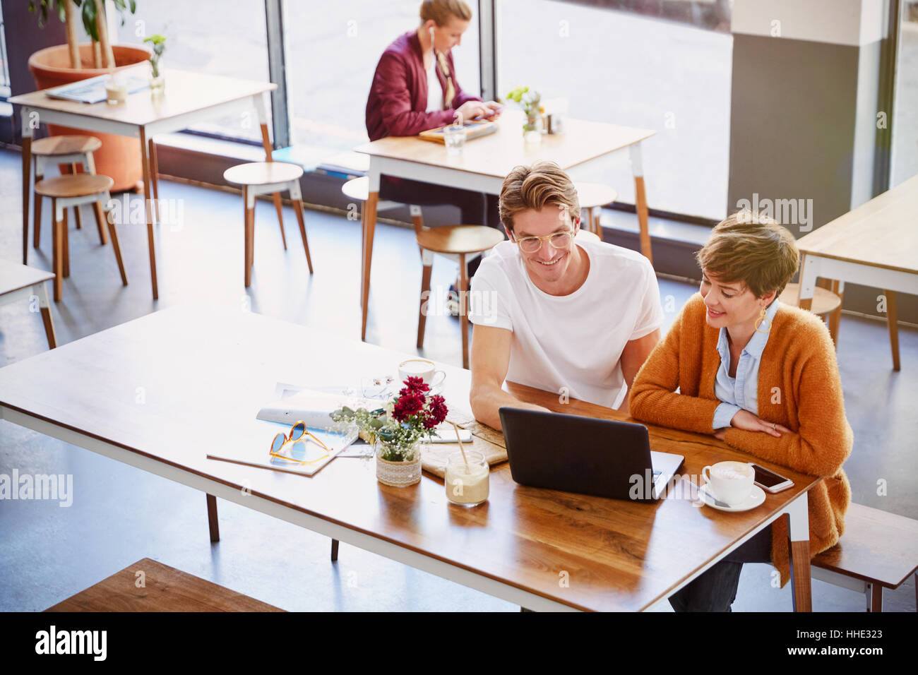 Business people drinking coffee meeting using laptop in cafe Stock ...