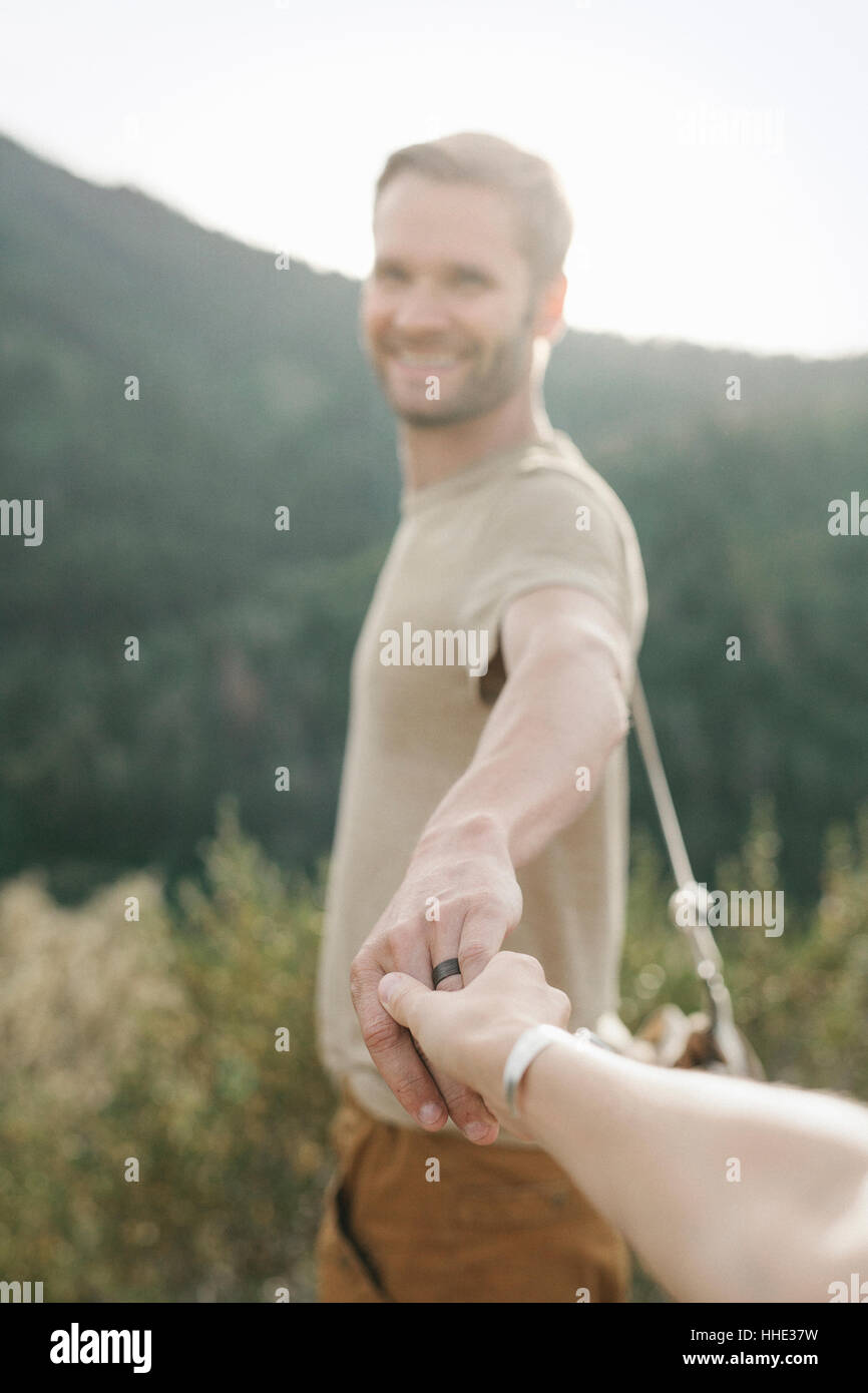 A man holding out his hand to a companion Stock Photo - Alamy