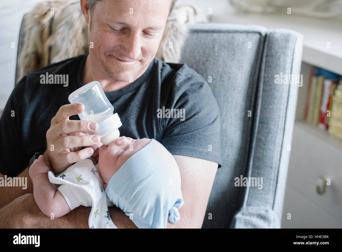 A father cradling a small baby and bottle feeding him Stock Photo - Alamy