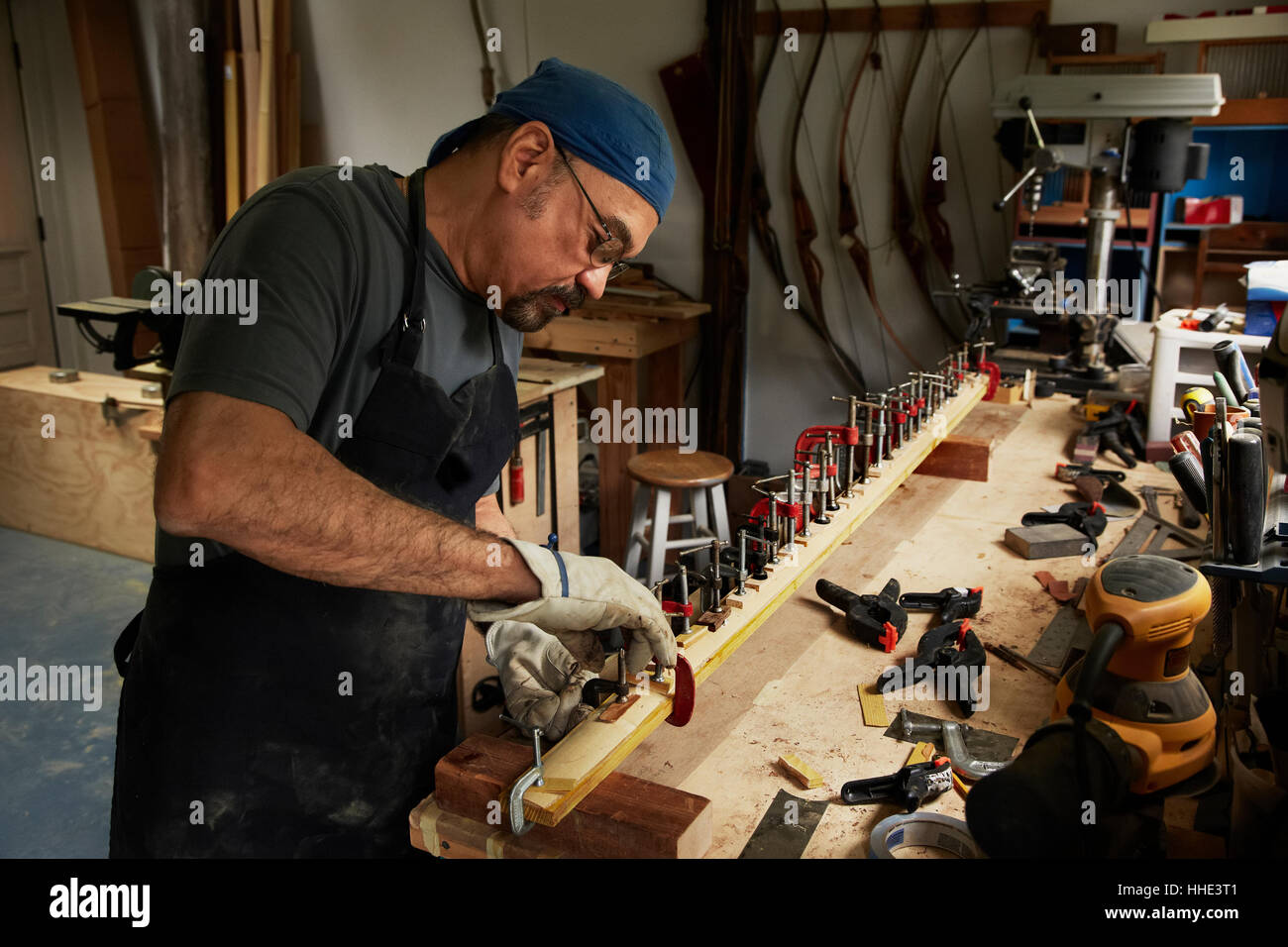 A bowman, a skilled man making a bow, in his workshop Stock Photo - Alamy