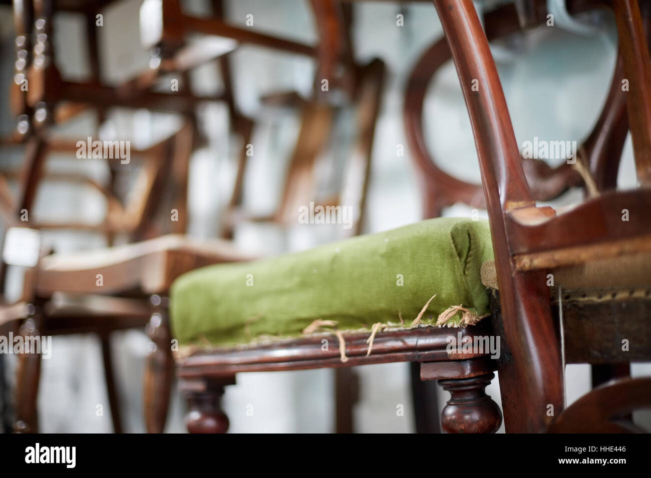 A stack of antique chairs, with fraying seas for refurbishment Stock ...