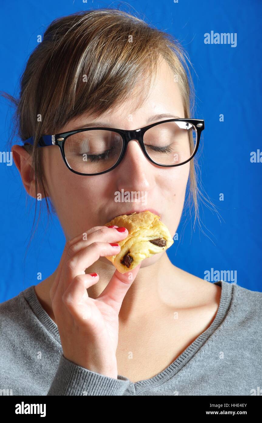 A teen eating a chocolate bun Stock Photo - Alamy