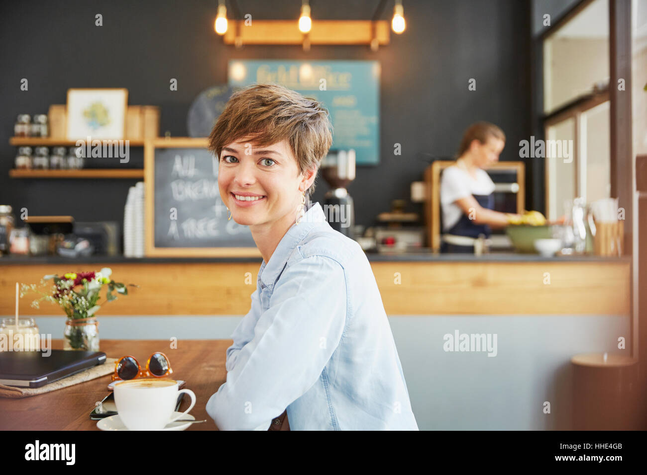 Portrait smiling woman drinking coffee at cafe table Stock Photo - Alamy
