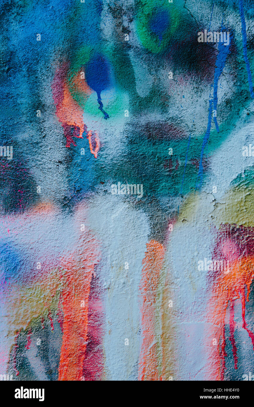 A wall daubed with colourful paint, graffiti, street art, close up ...