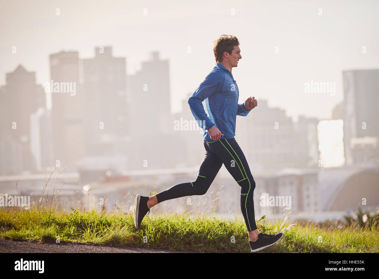 Male runner running on sunny urban street Stock Photo - Alamy