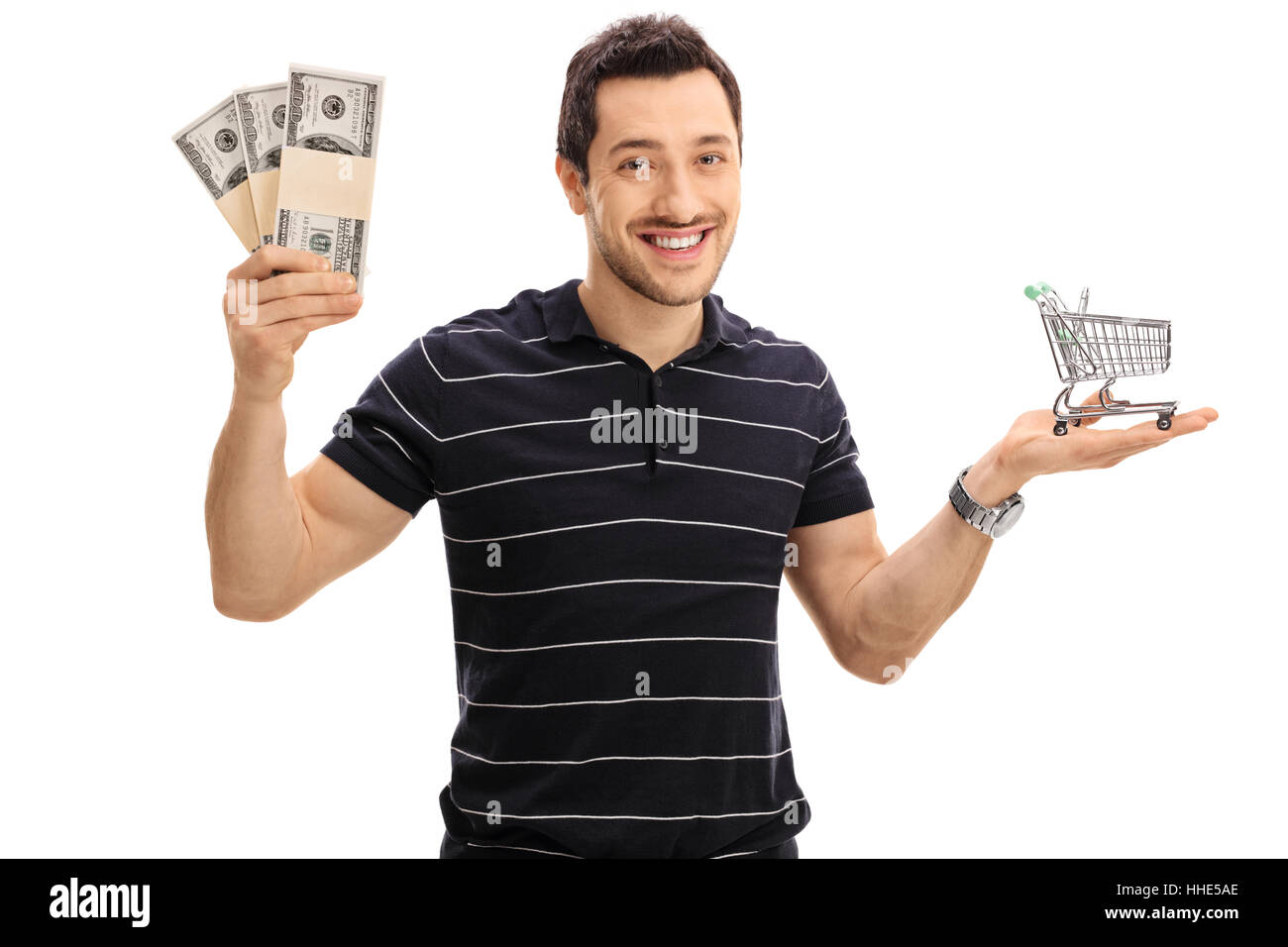 Happy guy holding money bundles and a small empty shopping cart ...