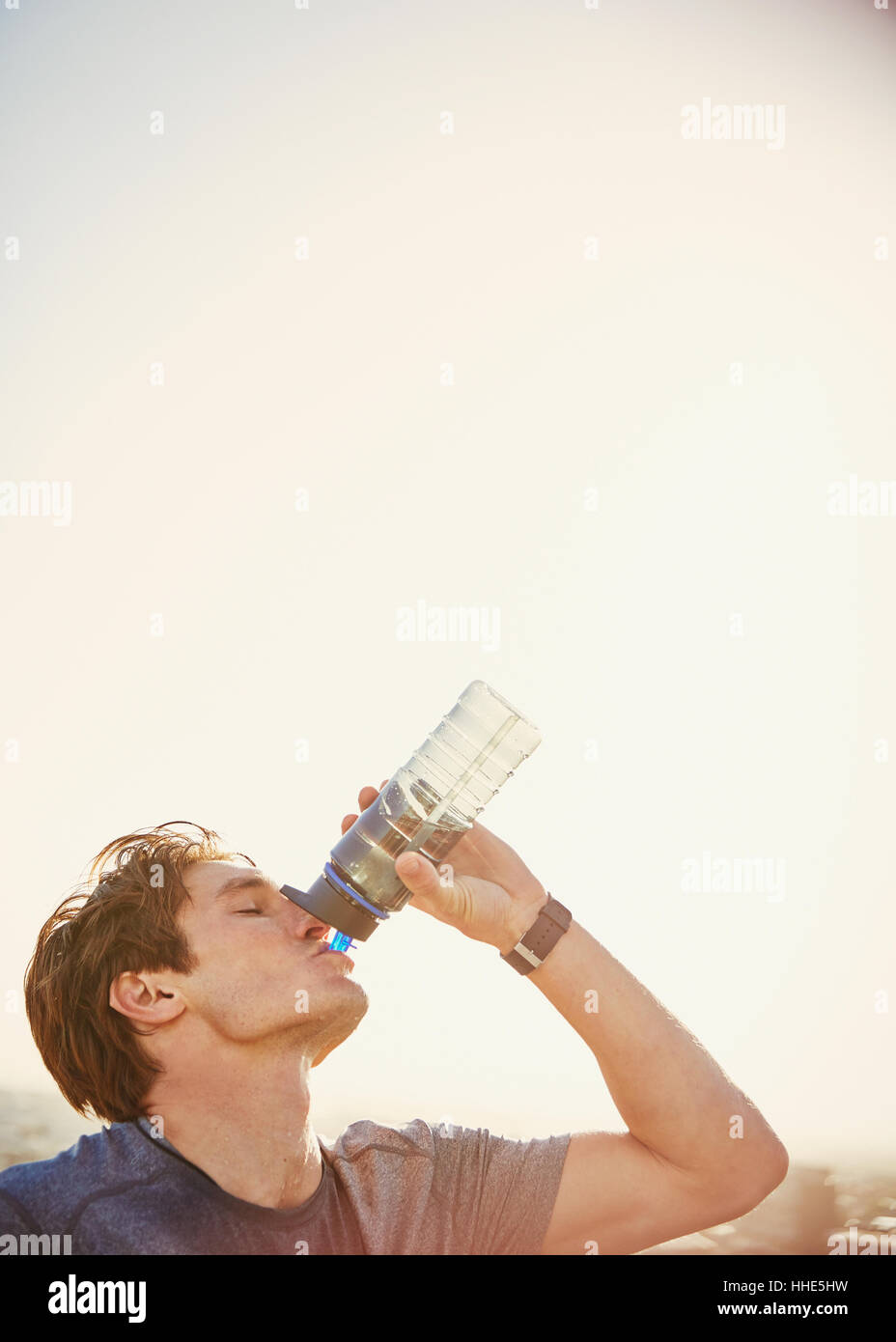 Thirsty male runner drinking water from water bottle Stock Photo - Alamy