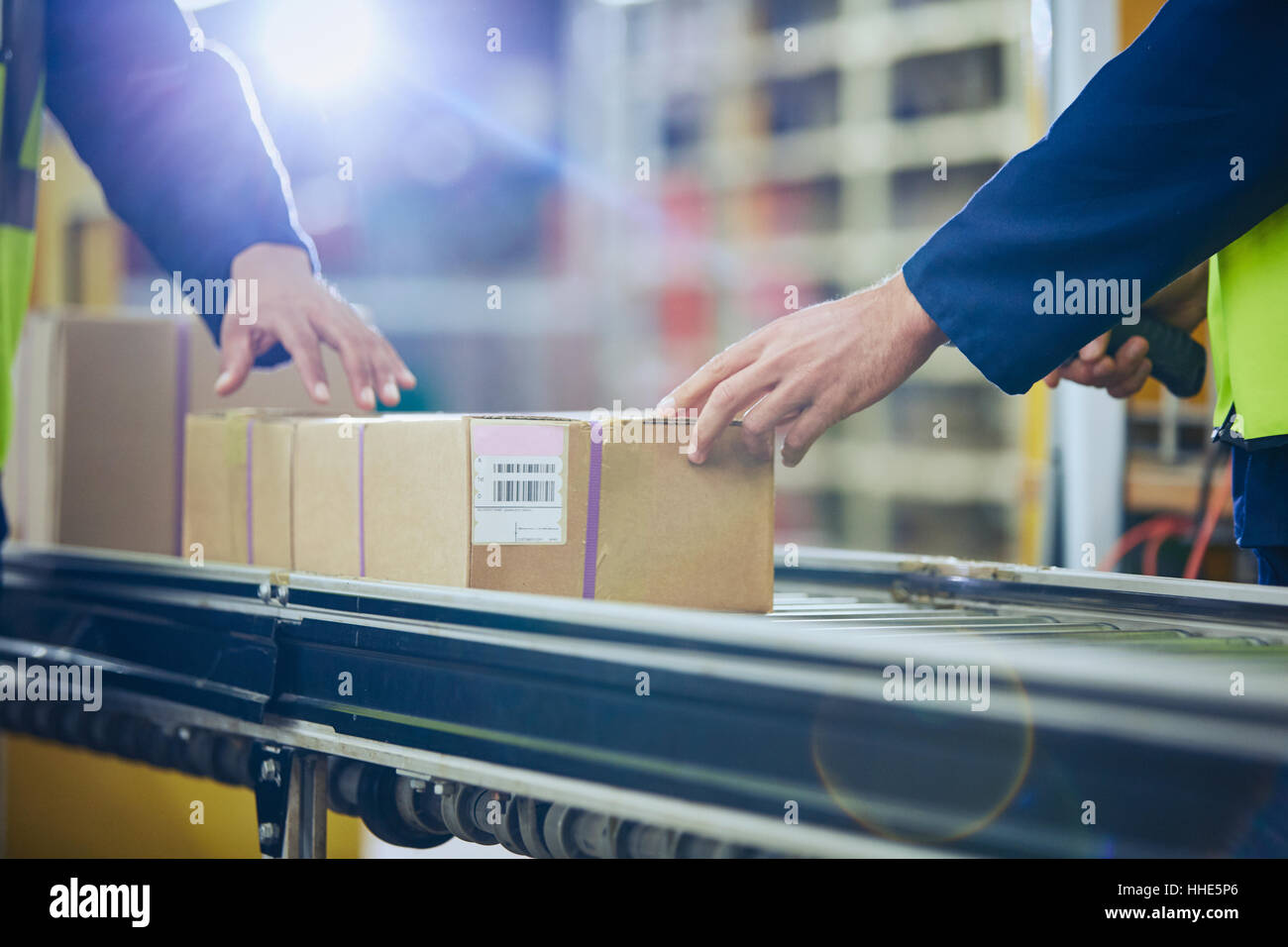 Workers scanning and processing boxes on conveyor belt in distribution ...