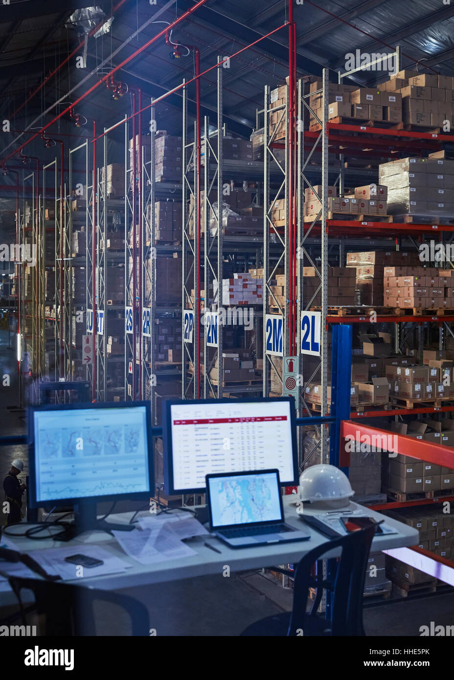 Desk with laptop and computers in distribution warehouse Stock Photo ...