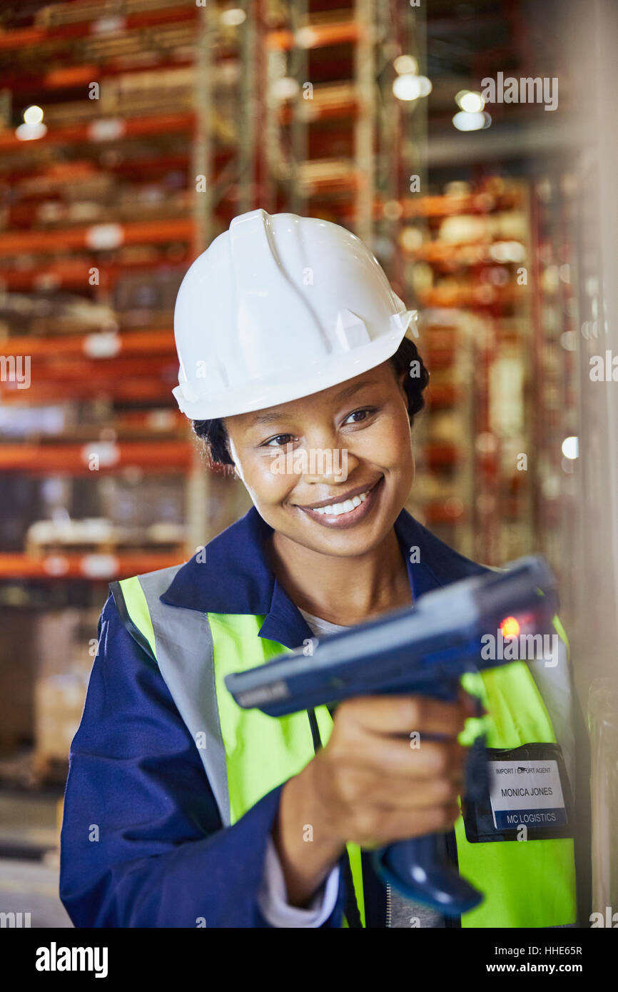 Smiling female worker using scanner in distribution warehouse Stock ...